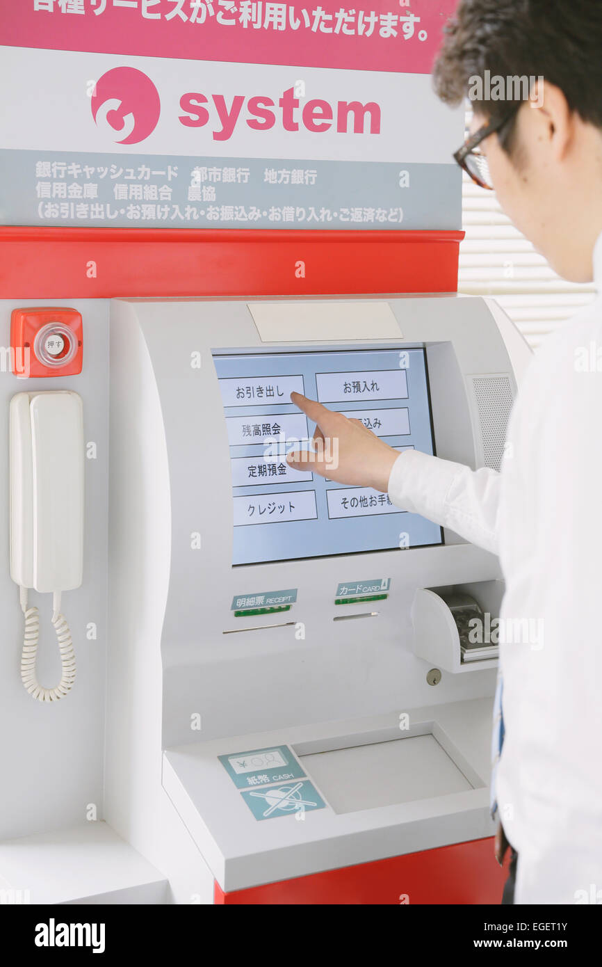 Japanese man using ATM in a convenience store Stock Photo - Alamy