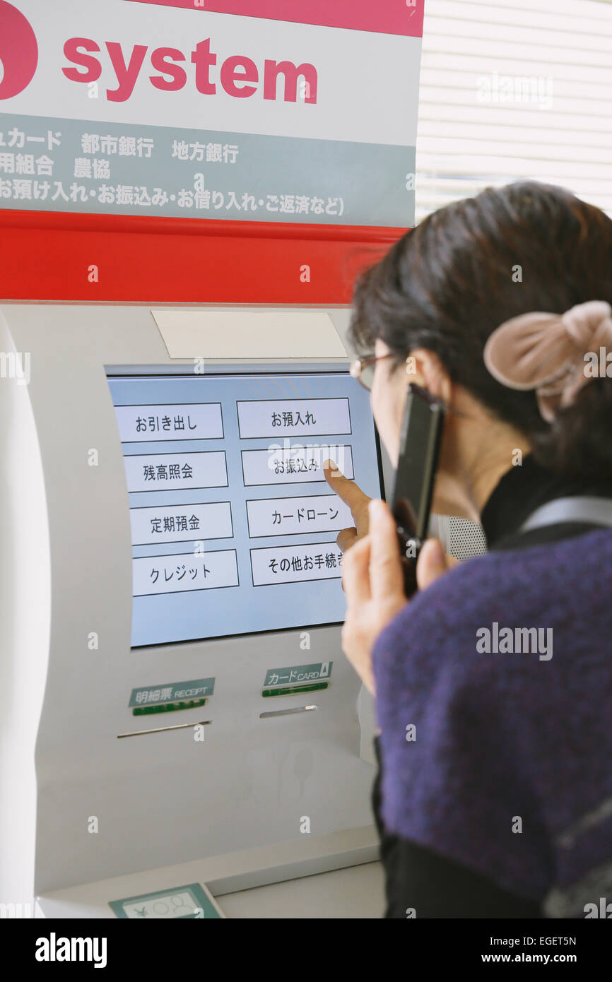Japanese woman using ATM in a convenience store Stock Photo - Alamy