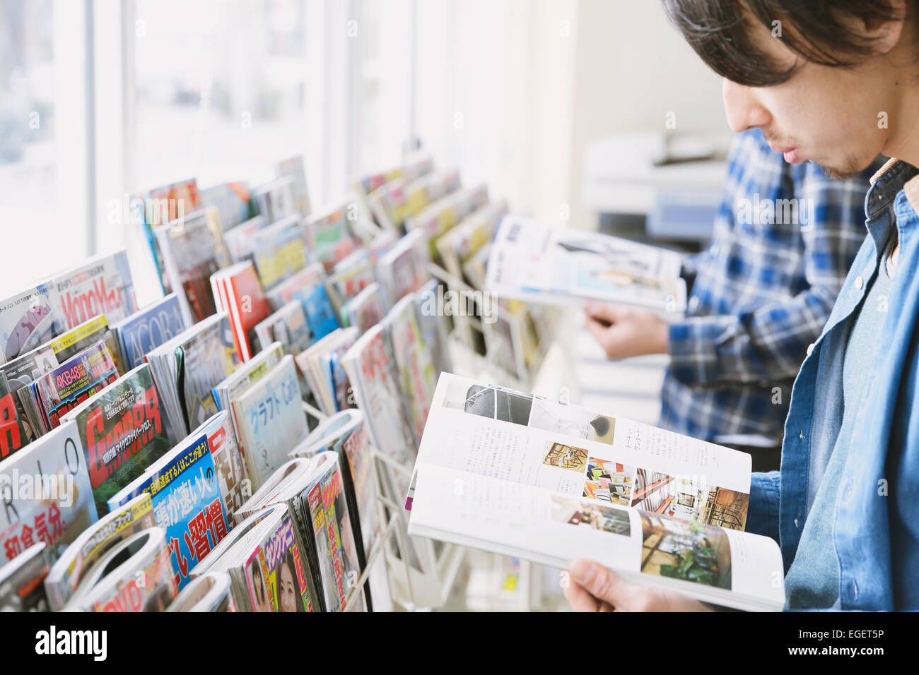Customer reading newspapers in a convenience store Stock Photo - Alamy
