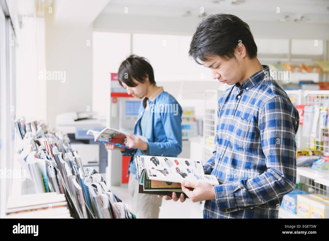 Customer reading newspapers in a convenience store Stock Photo - Alamy