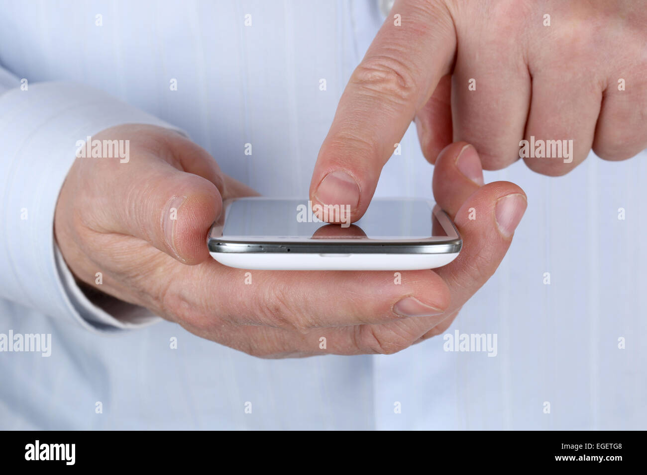 A senior businessman using a smartphone by tipping with his fingers ...