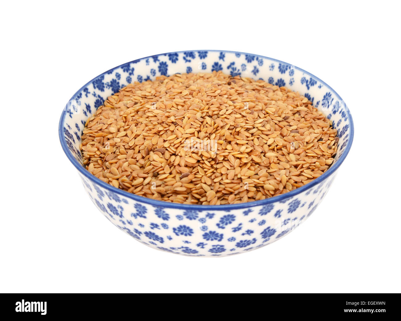 Golden linseed or flax seeds in a blue and white porcelain bowl with a ...
