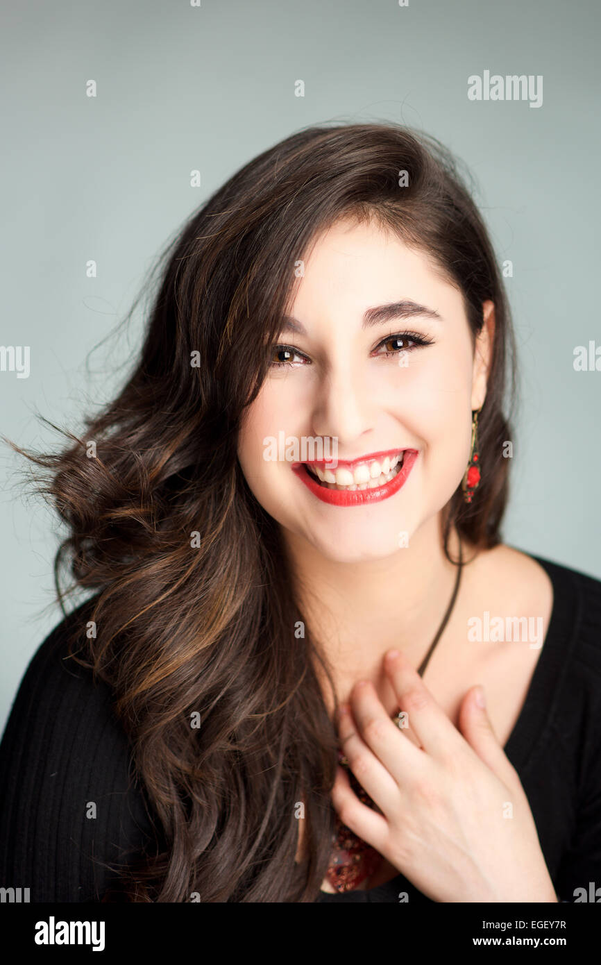 Smiling happy look hispanic girl on grey background Stock Photo - Alamy