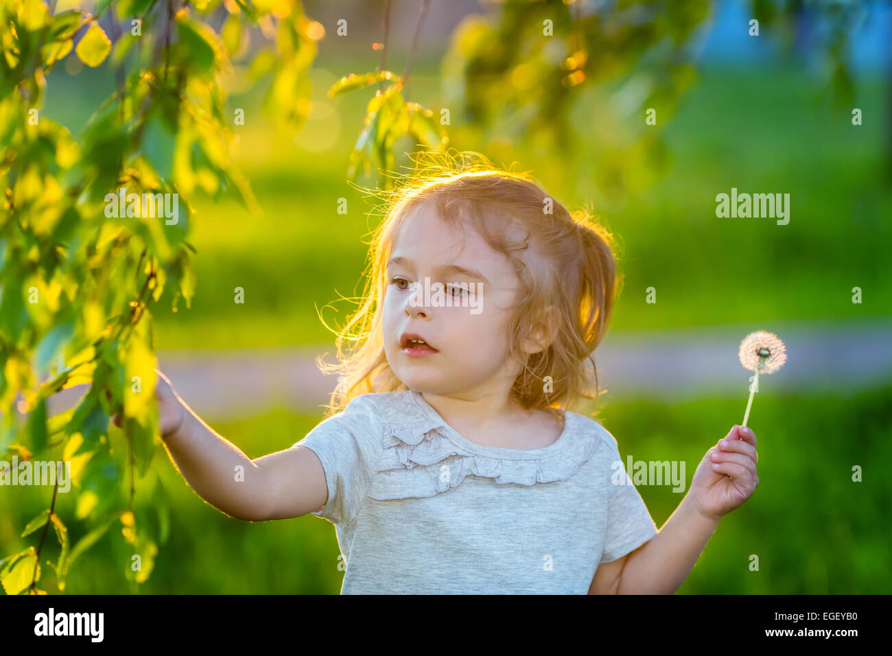 Little girl in spring sunny park Stock Photo - Alamy