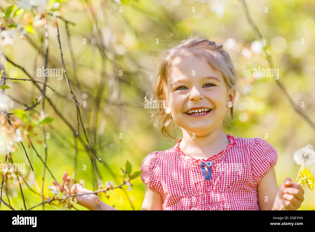 Happy little girl in spring sunny park Stock Photo - Alamy