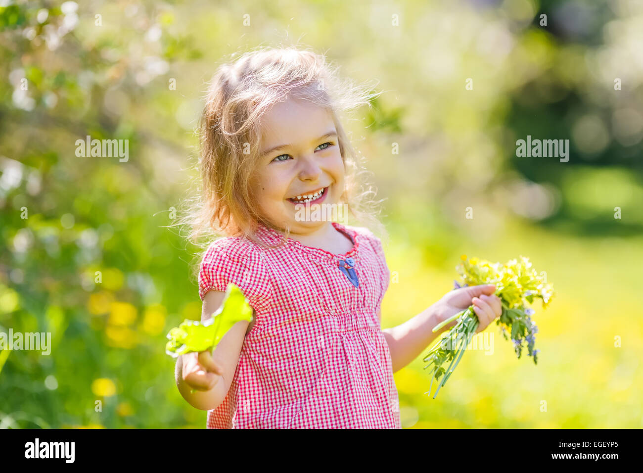 Happy little girl in spring sunny park Stock Photo - Alamy