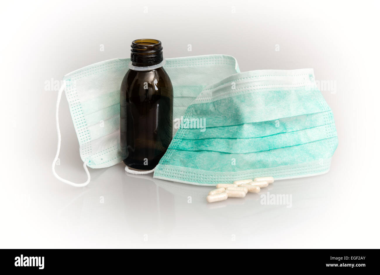 Two medical masks, pills and cough syrup bottle on the white background ...