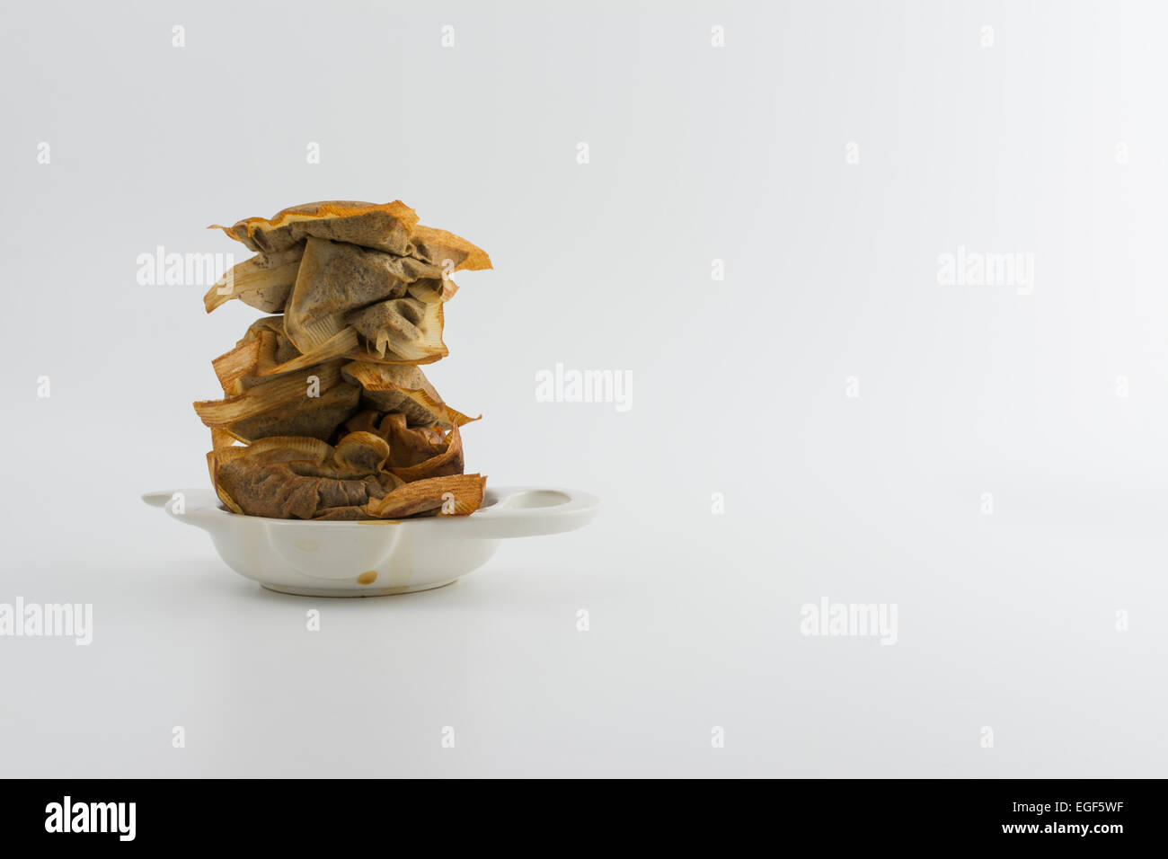 Procrastination - stack of used teabags in stained tea bag holder with ...