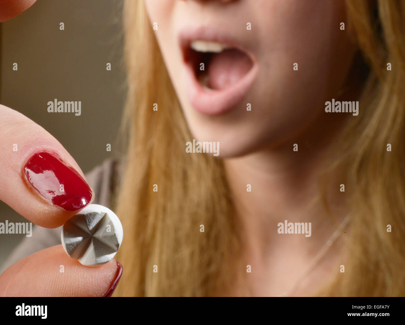 The symbol photo "medicine" shows a young woman in taking a tablet ...