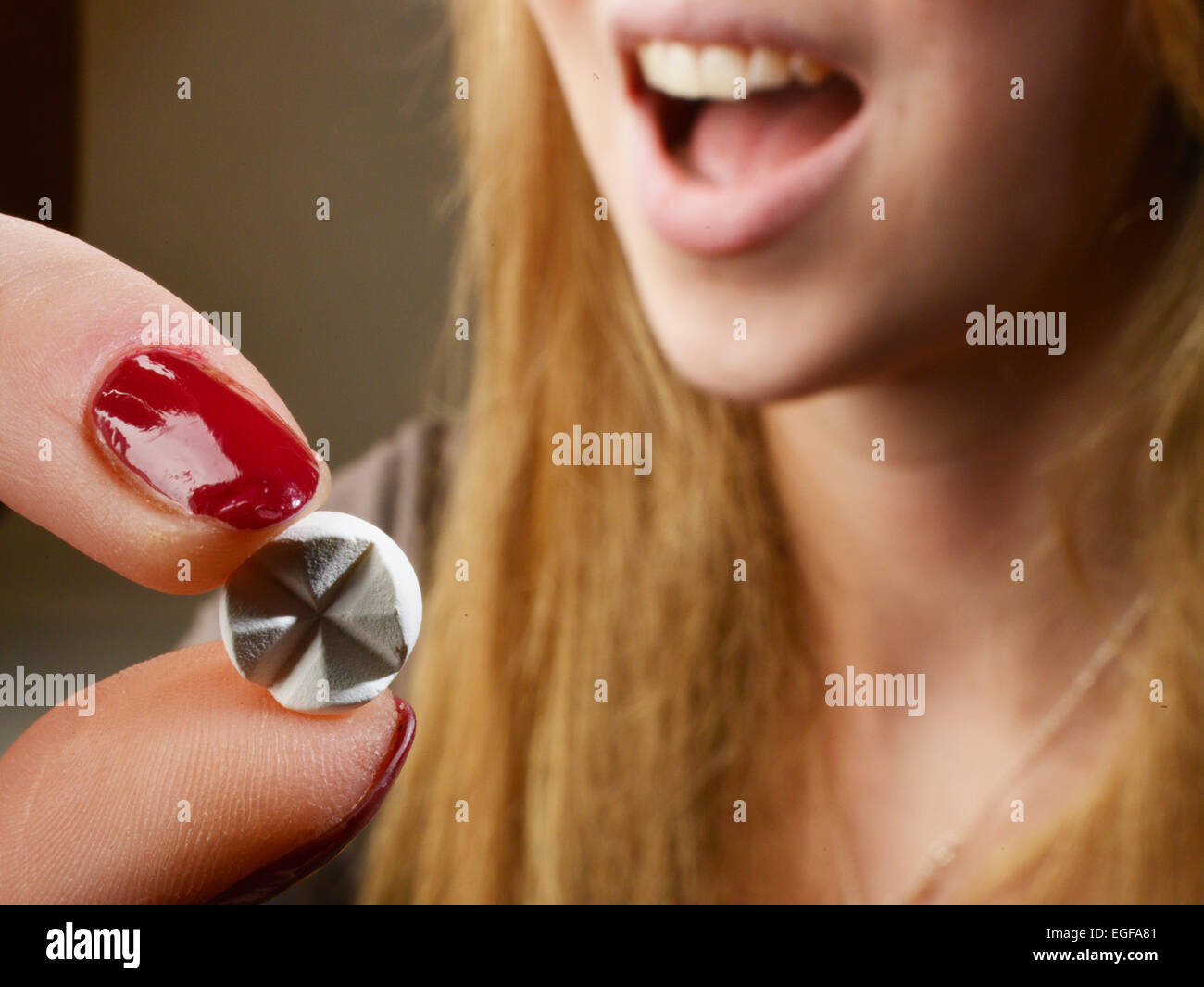 The symbol photo "medicine" shows a young woman in taking a tablet ...