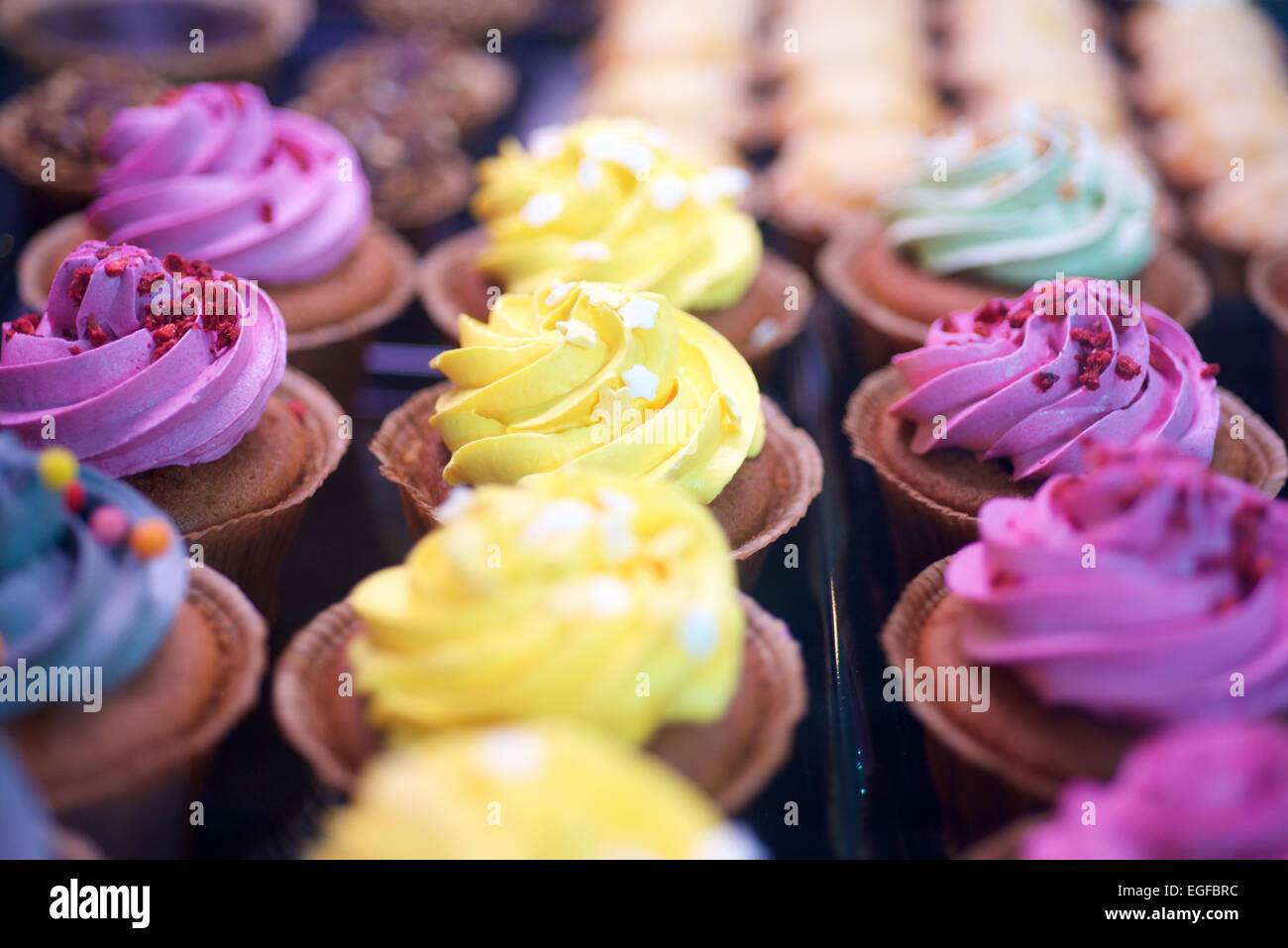 Colorful cupcakes in window display in store Stock Photo - Alamy