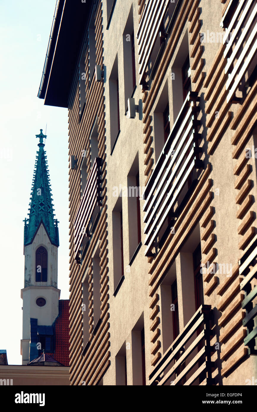 Church spire and the facade of a modern building in Riga. Vecriga ...