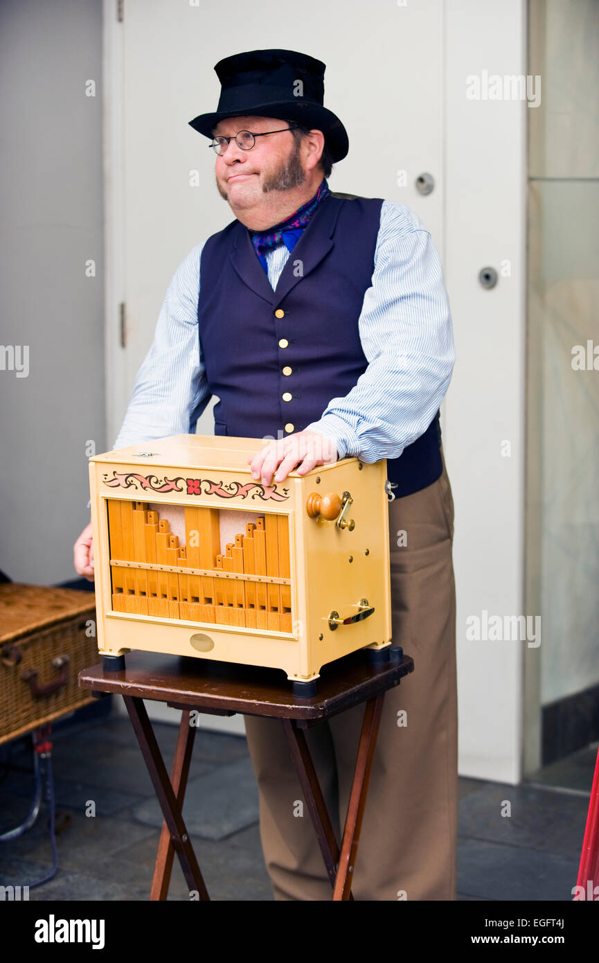 character in victorian dress turning a hand organ at the dickens ...