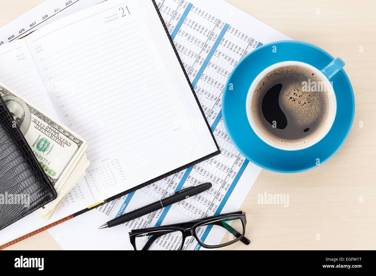 Office desk with reports, blank notepad and money cash. View from above ...