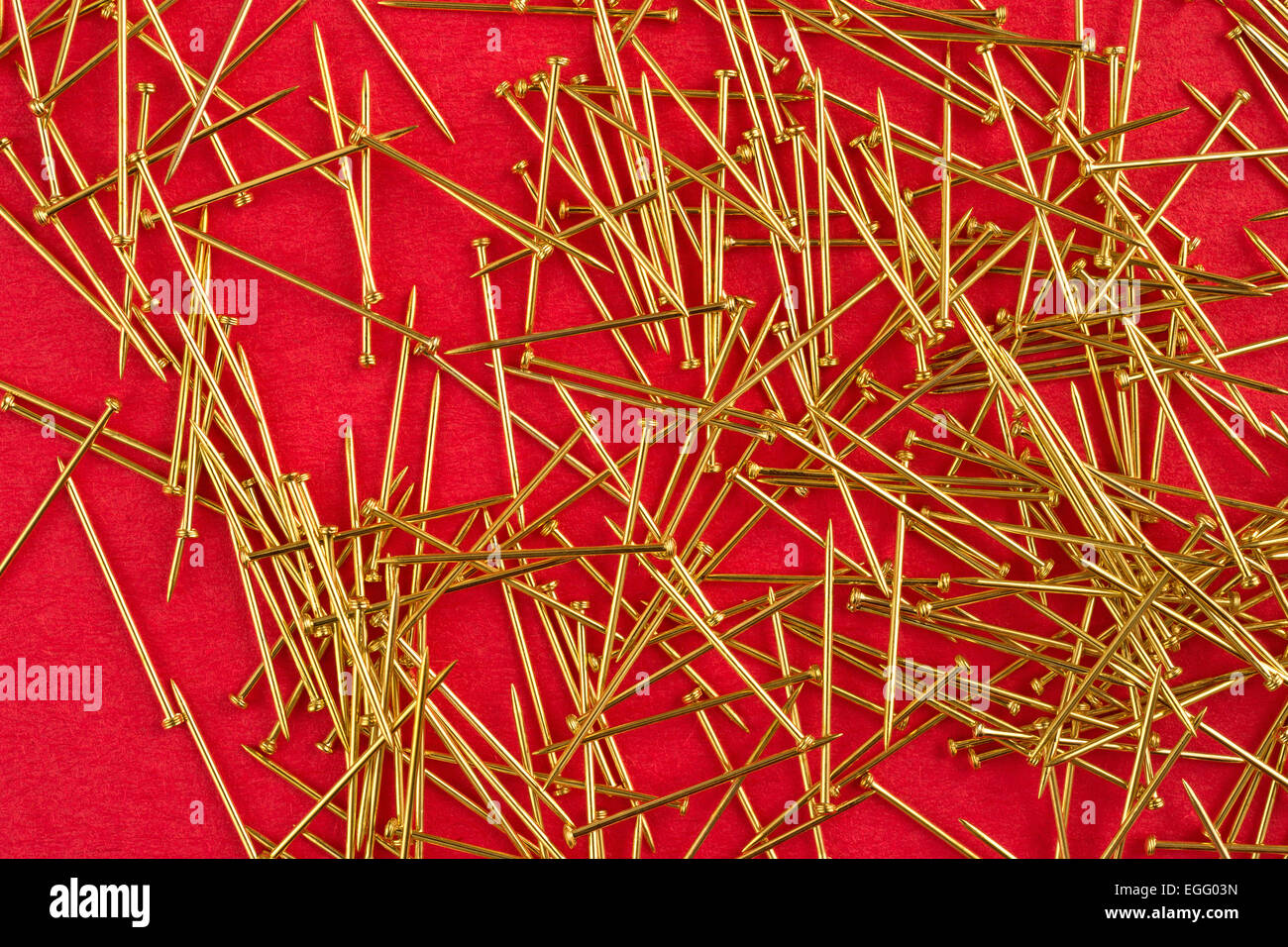 Top view of gold sequin pins on a red background Stock Photo - Alamy