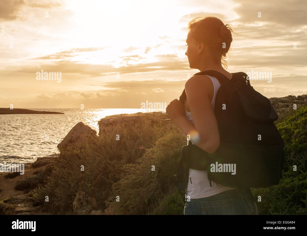 Woman with backpack on the sunset Stock Photo - Alamy
