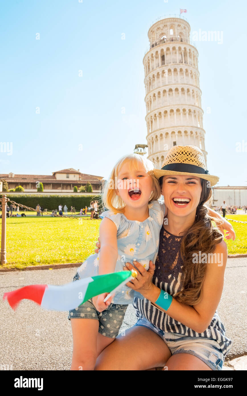 Portrait of smiling mother and baby girl with italian flag in front of ...