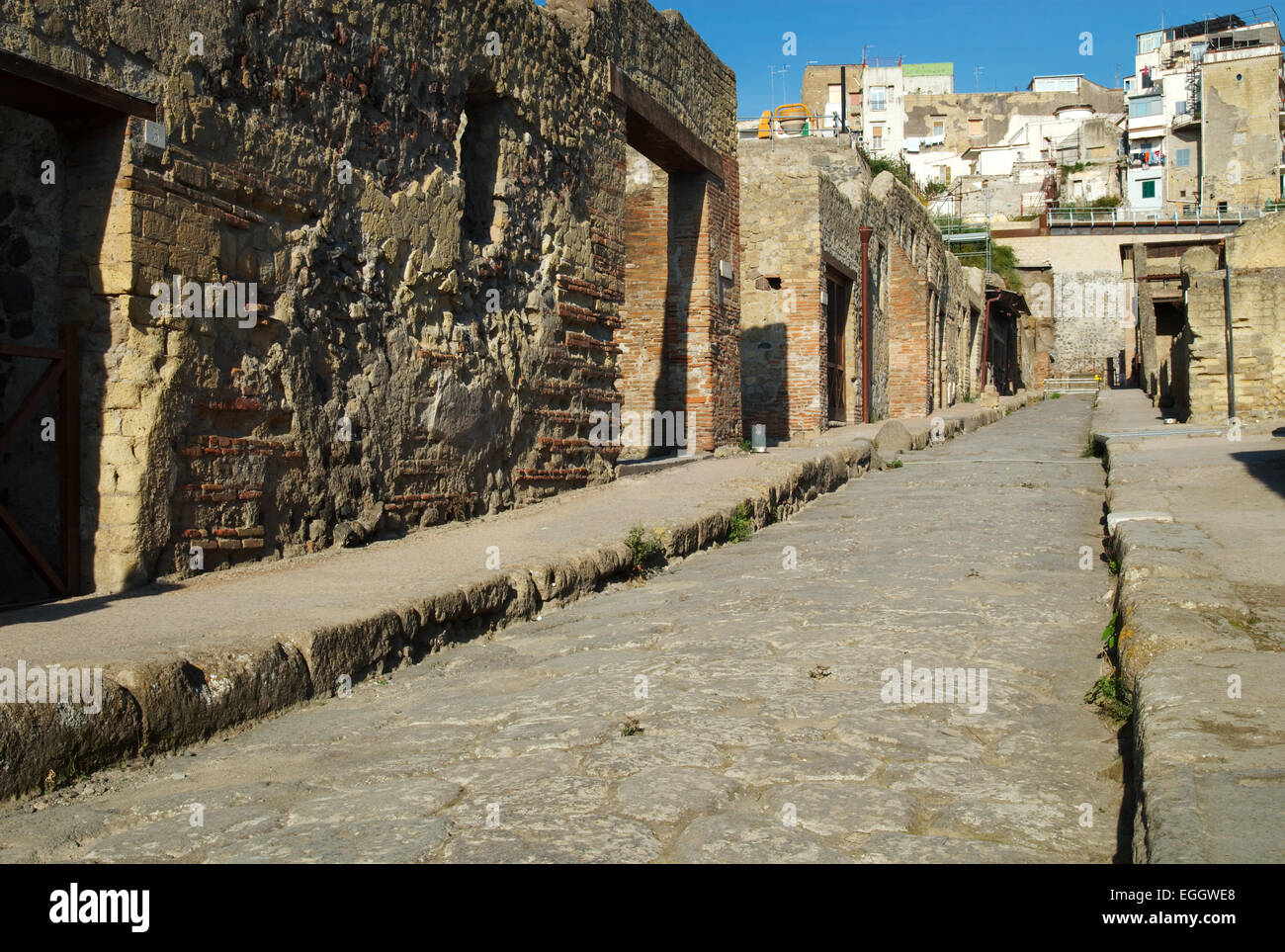 An empty street runs between the remains of ancient roman buildings ...