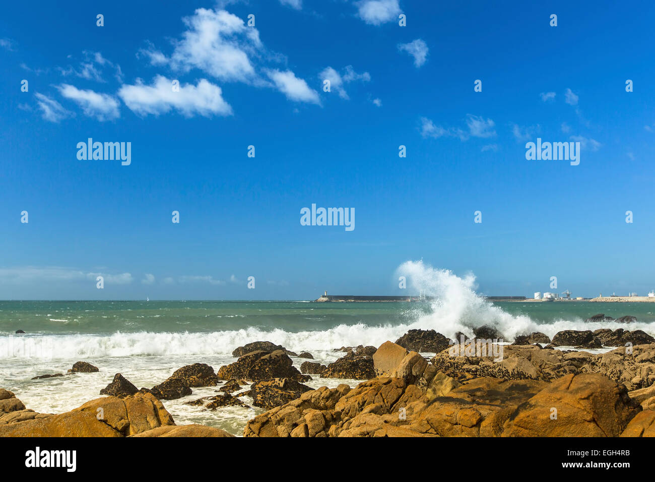 Ocean surf, blue sky and splash over the stones Stock Photo - Alamy