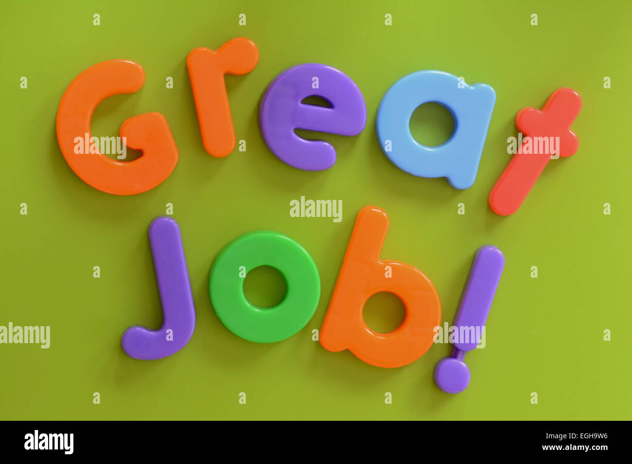 Close up of Great Job! words in colorful plastic letter toys on green ...
