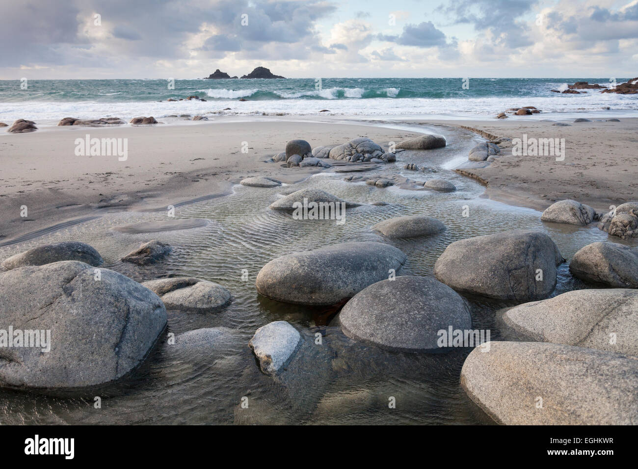 Rocks in freshwater stream flowing to sea, "Porth Nanven" beach and the ...