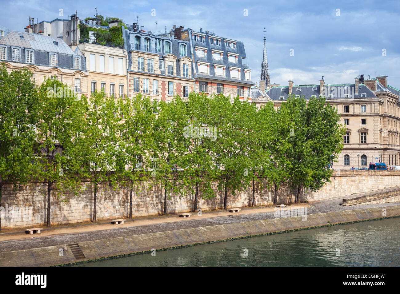 Seine river embankment with trees and old houses facades Stock Photo ...