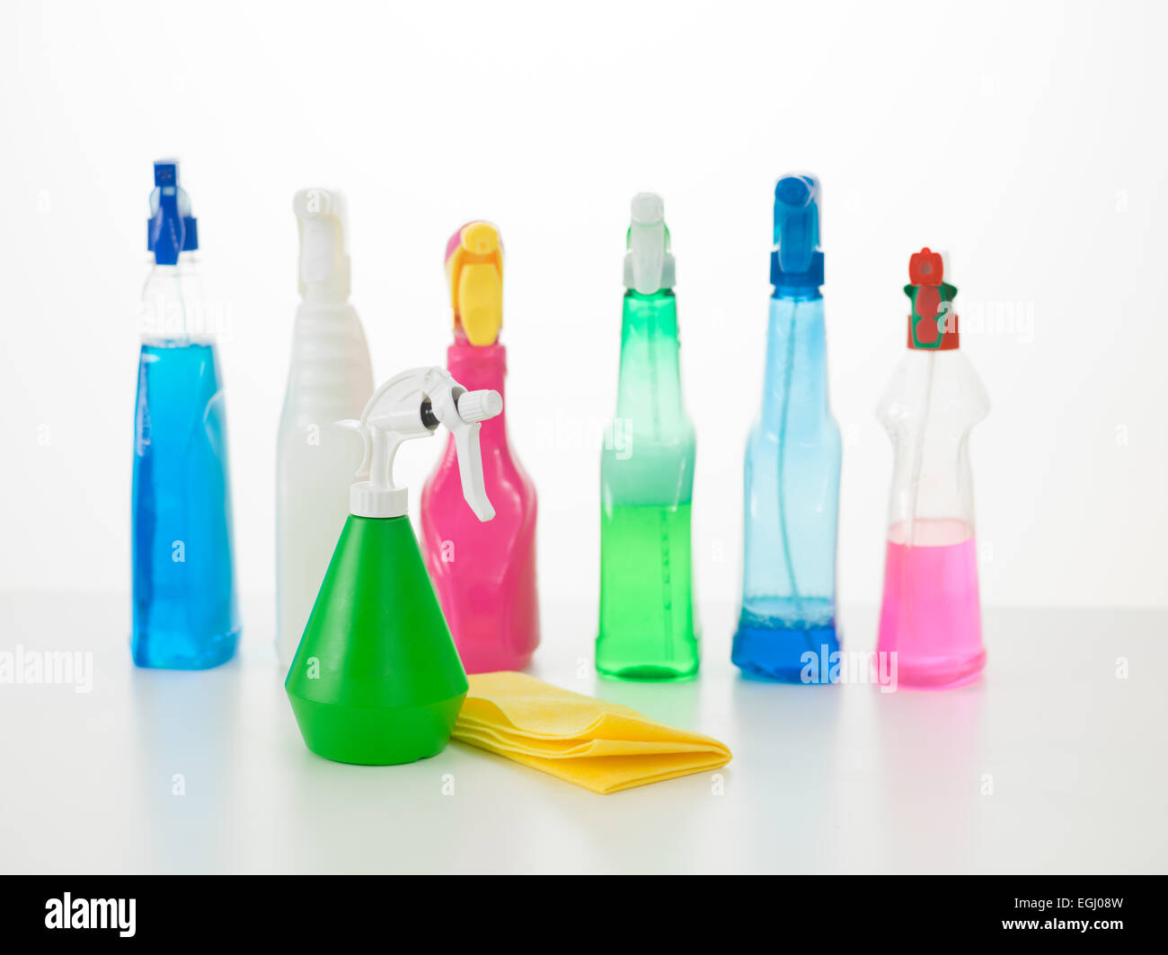 group of colorful spray bottles with cleaning liquid on white table ...