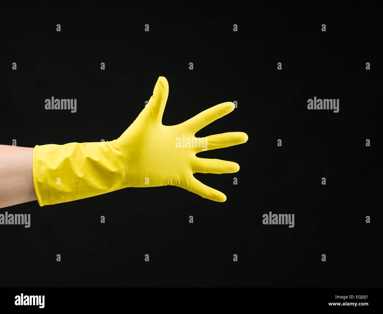 open hand with yellow rubber glove on black background Stock Photo - Alamy