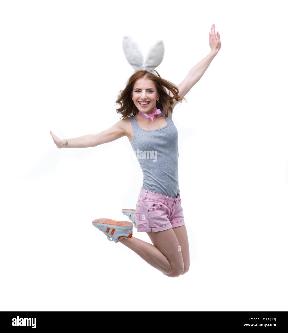 Happy woman in rabbit ears jumping over white background Stock Photo ...