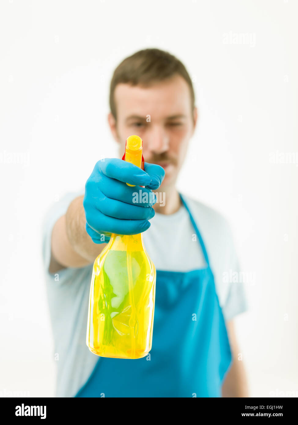 young caucasian male pointing cleaning spray bottle in front of him ...