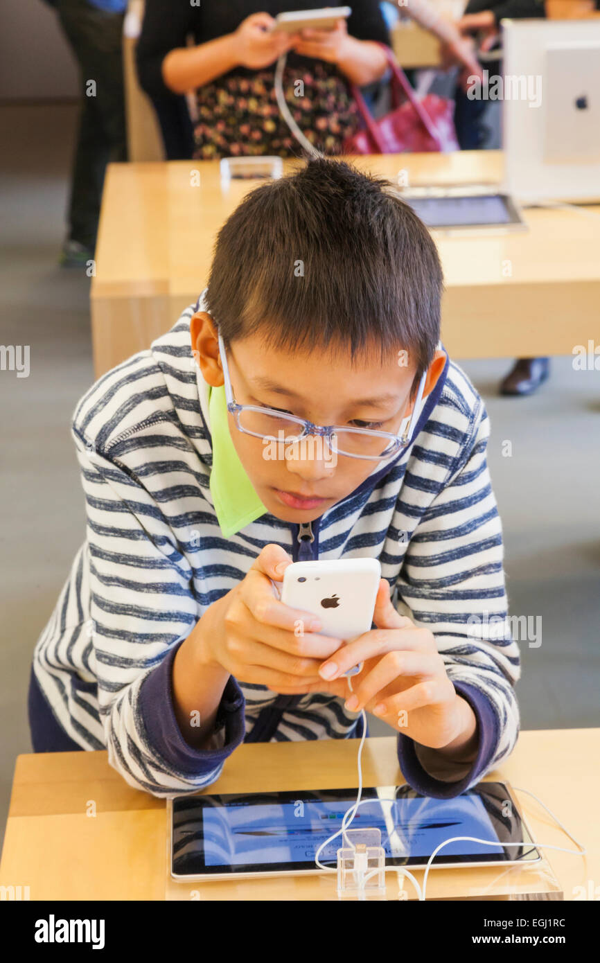 China, Hong Kong, Apple Store, Young Boy Looking at iPhone Stock Photo ...