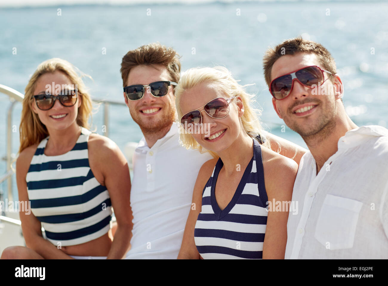 smiling friends sitting on yacht deck Stock Photo - Alamy