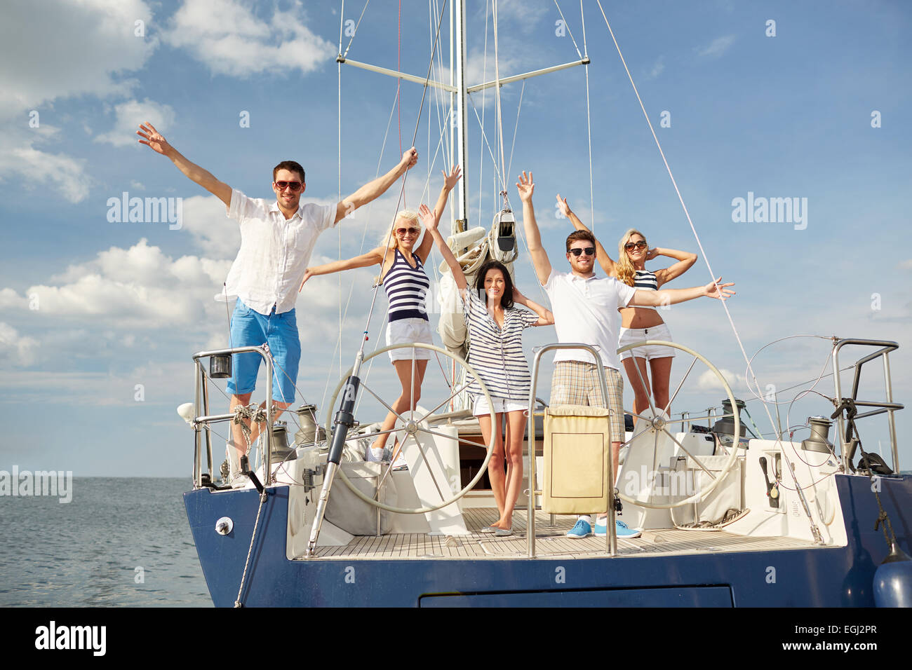 smiling friends sitting on yacht deck and greeting Stock Photo - Alamy