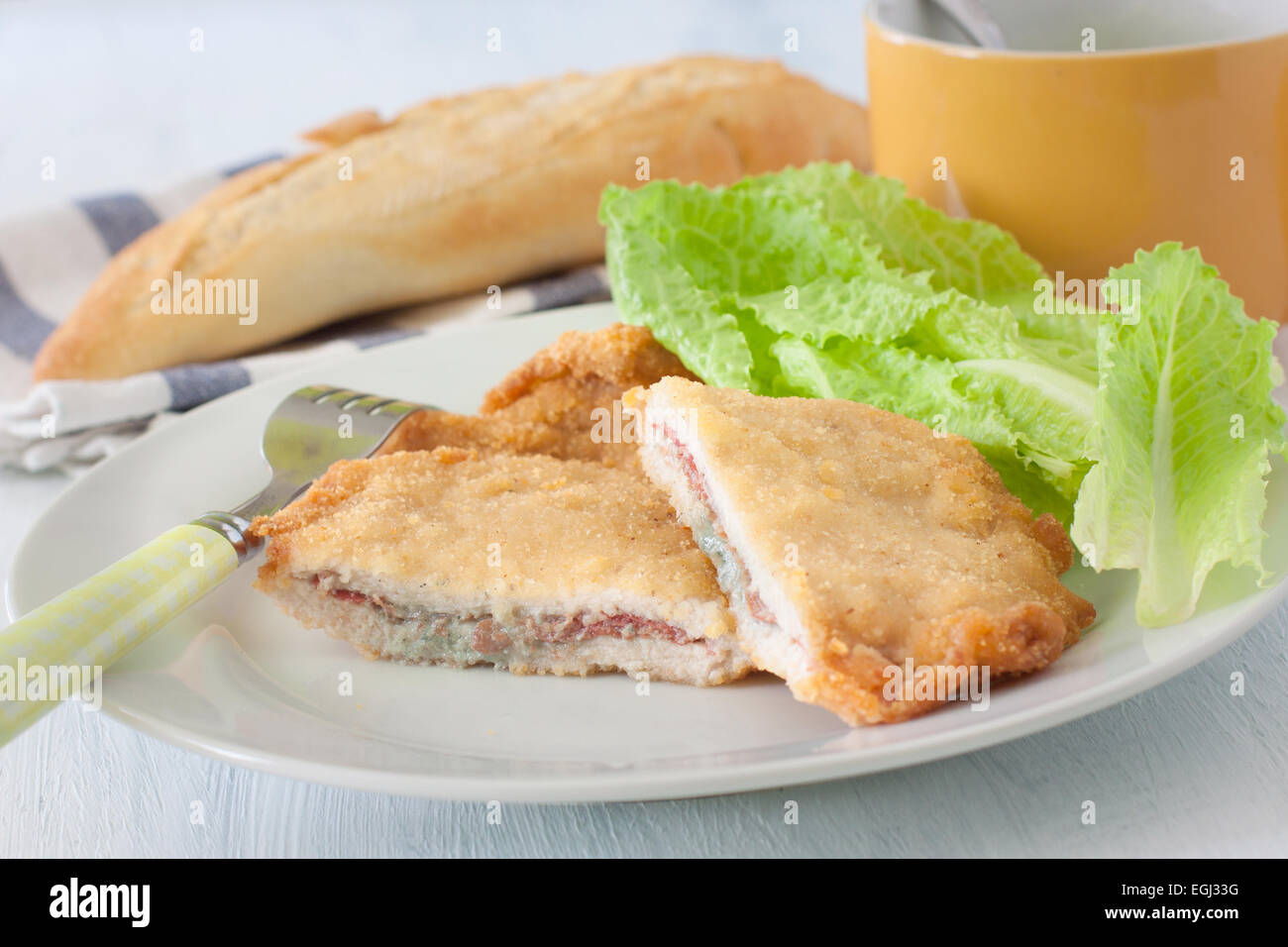french deep fried cordon bleu with salad on white plate Stock Photo - Alamy