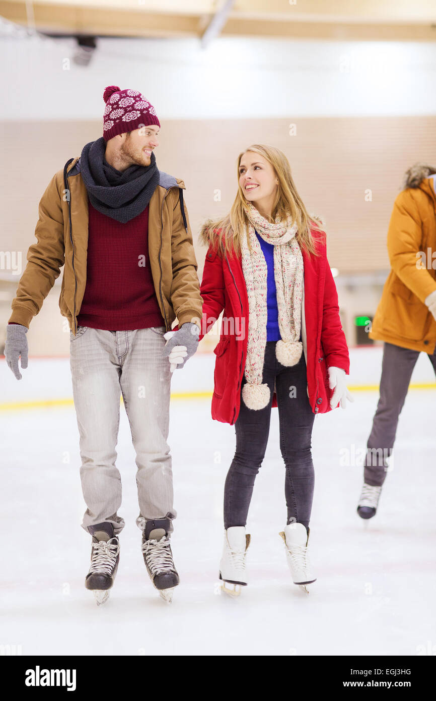 happy couple holding hands on skating rink Stock Photo - Alamy
