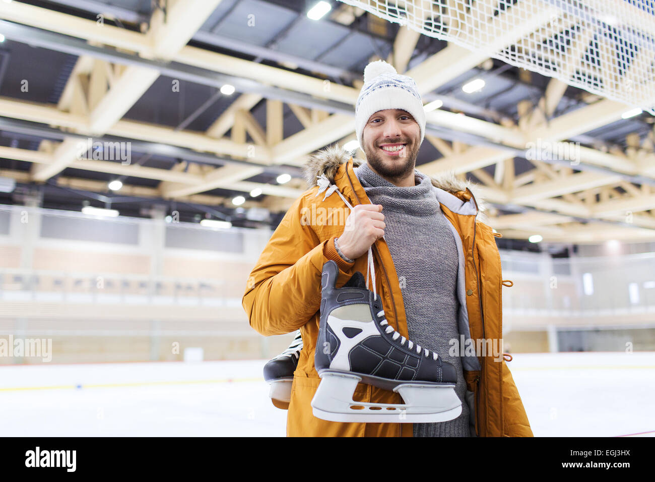 happy young man with ice-skates on skating rink Stock Photo - Alamy