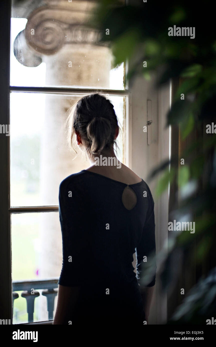 Young woman at the window Stock Photo - Alamy