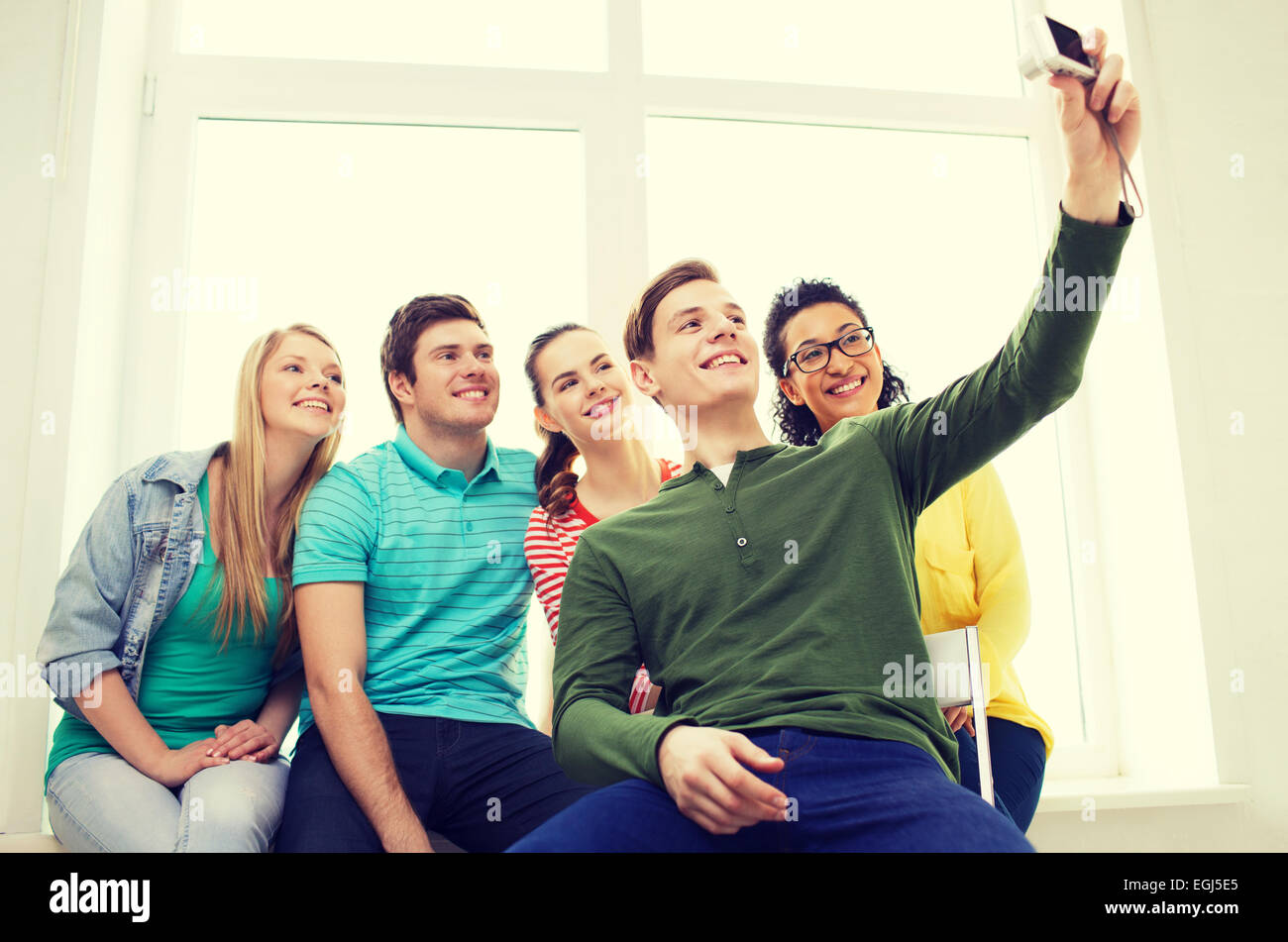 five smiling students taking picture with camera Stock Photo - Alamy