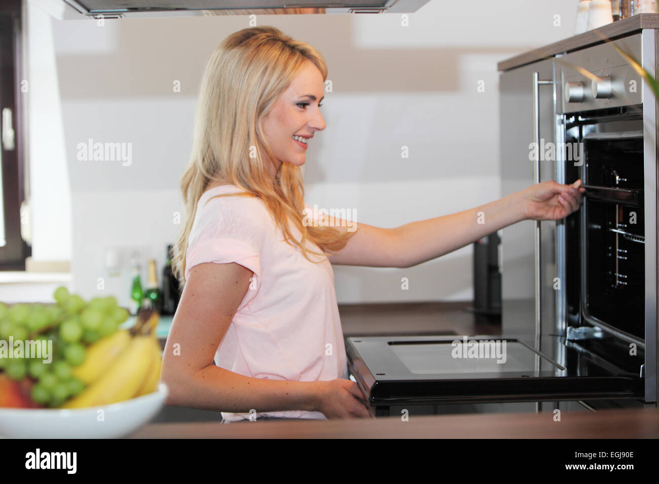 Close up Side View of Happy Blond Woman Cooking Food for Dinner Using ...