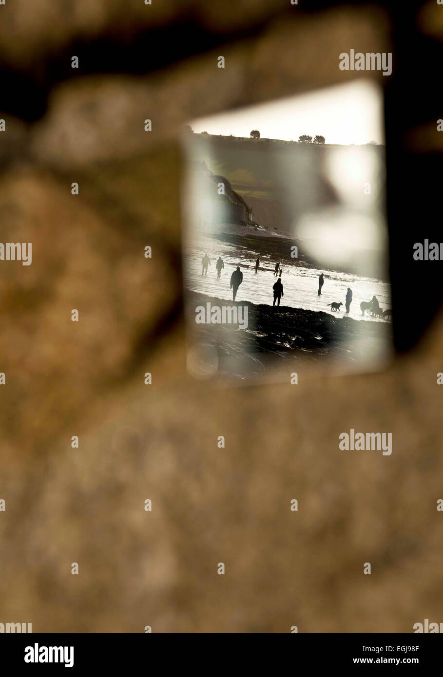 Mirror reflecting people walking on a beach. Concept Stock Photo - Alamy