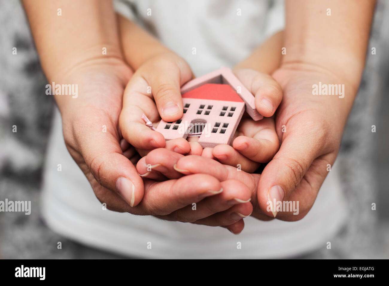 Woman and child hand hold house model Stock Photo - Alamy