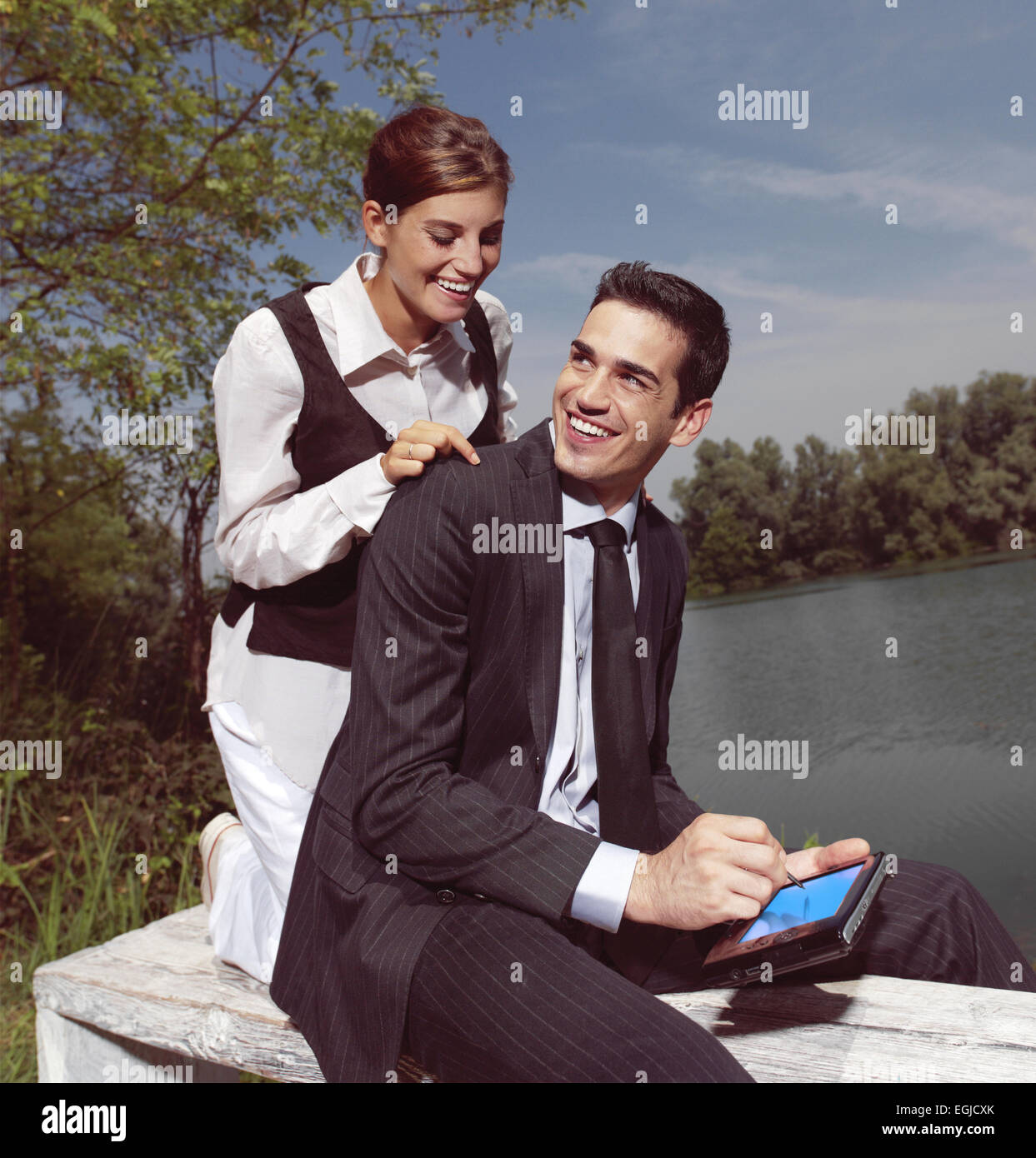 Beautiful young people using PDA outdoors Stock Photo - Alamy