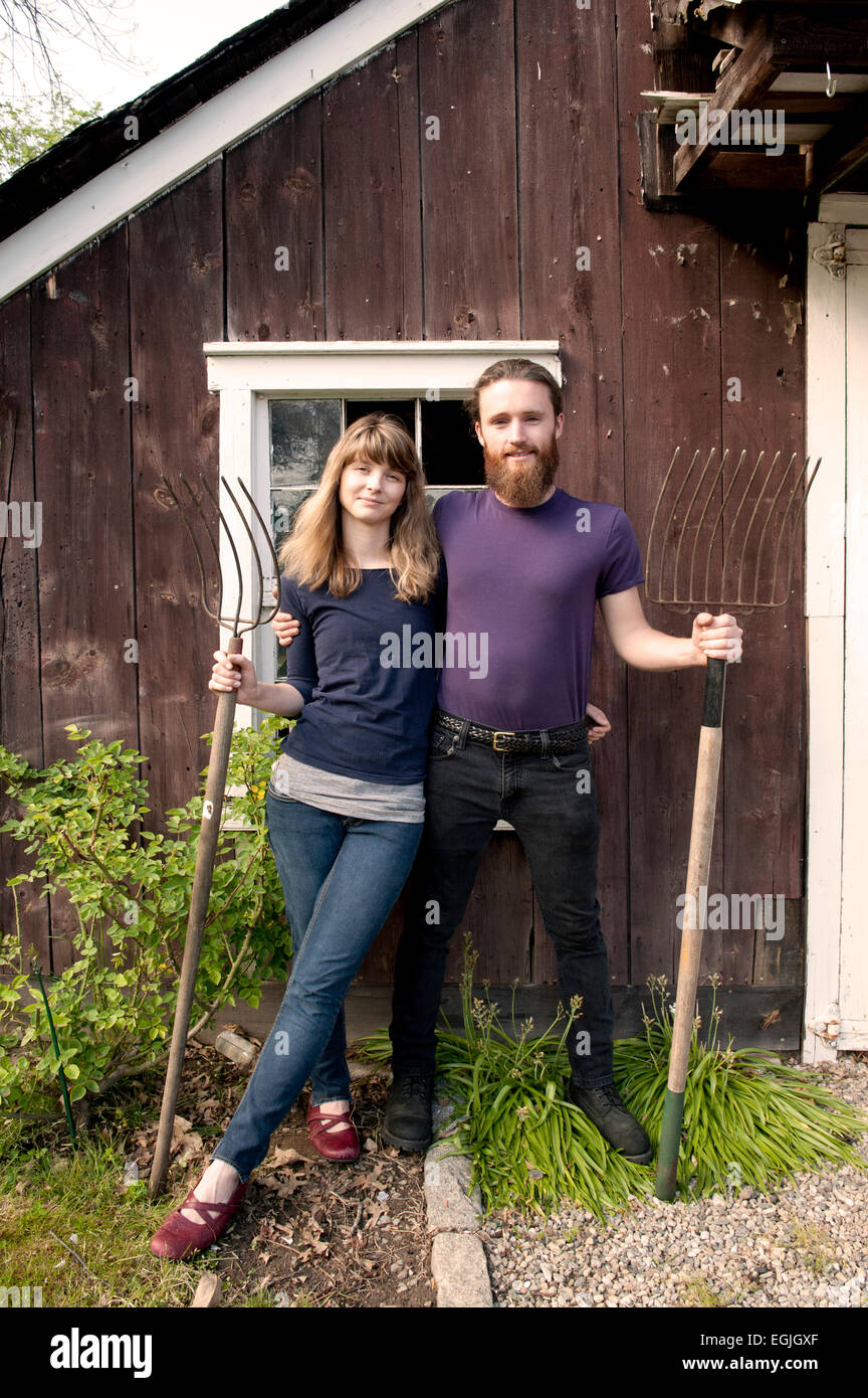 Smiling young white couple standing infront of barn in Connecticut ...