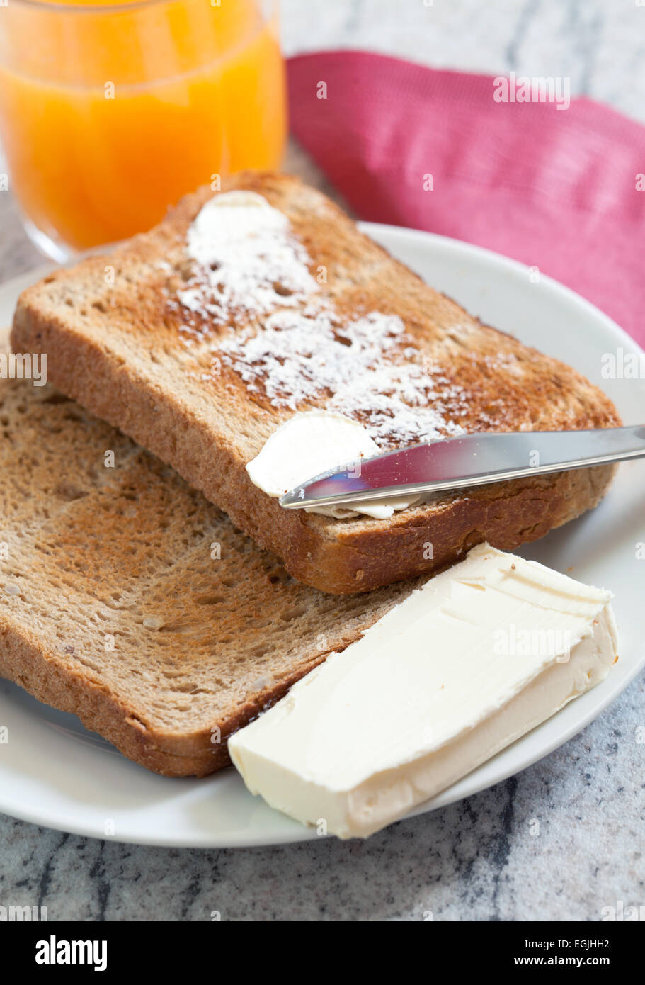 Morning toast with butter and a glass of fresh orange juice Stock Photo ...