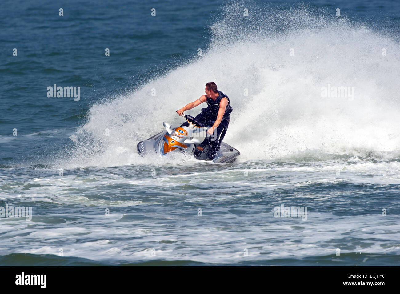 Man creating a splash on jet ski Stock Photo - Alamy
