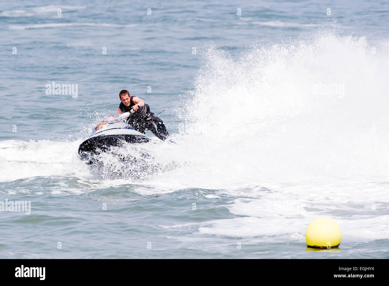 Man creating a splash on jet ski Stock Photo - Alamy