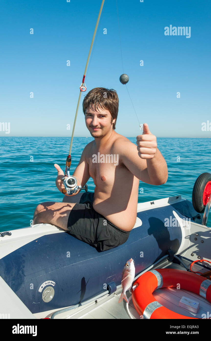 A boy fishing on a boat at the sea and take a fish Stock Photo - Alamy