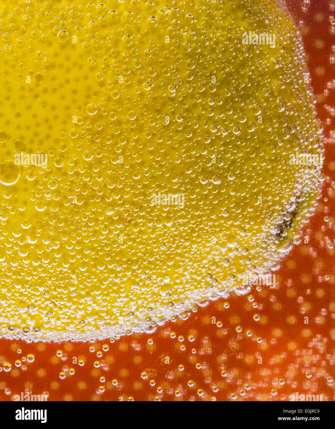 Lemon emerged in tonic water with an orange background Stock Photo - Alamy