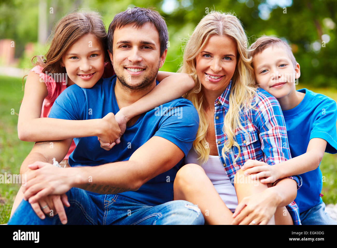 Happy couple and their two children looking at camera outside Stock ...