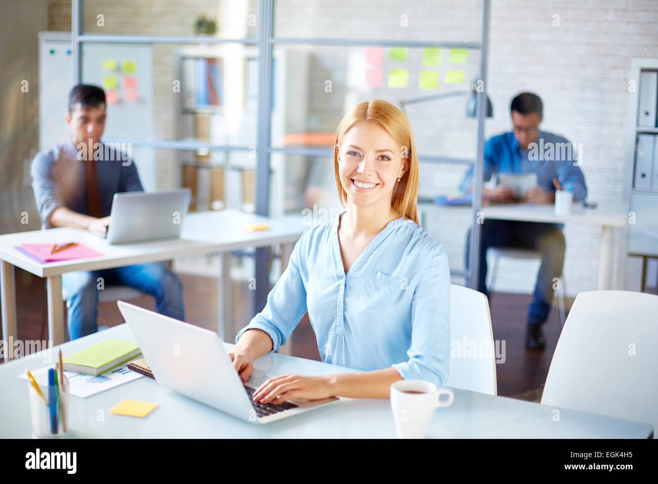 Businesswoman in casualwear looking at camera at workplace Stock Photo ...